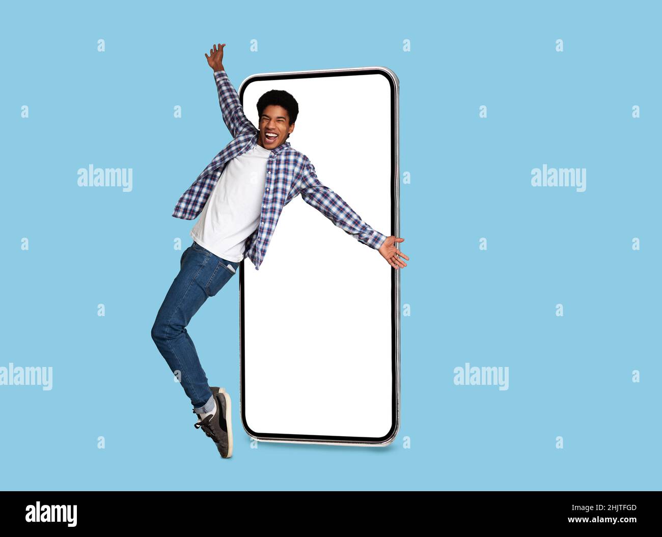 Cheerful young african american guy jumping for joy from blank screen ...