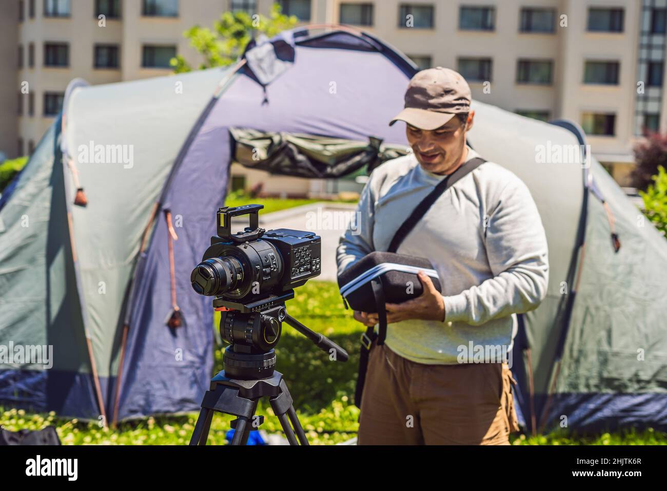 a professional cameraman prepares a camera and a tripod before shooting ...