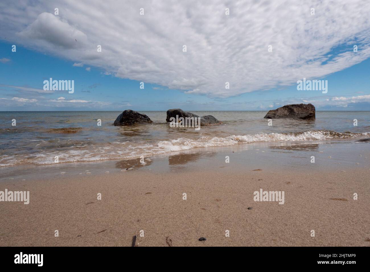 beautiful, smooth sandy beach with some boulders and interesting clouds ...