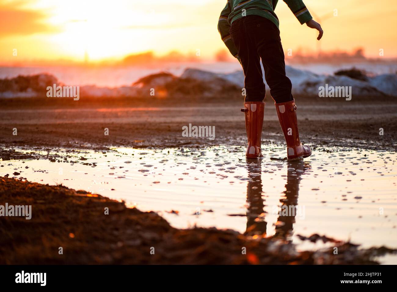 a child walking through a mud puddle during sunset Stock Photo - Alamy