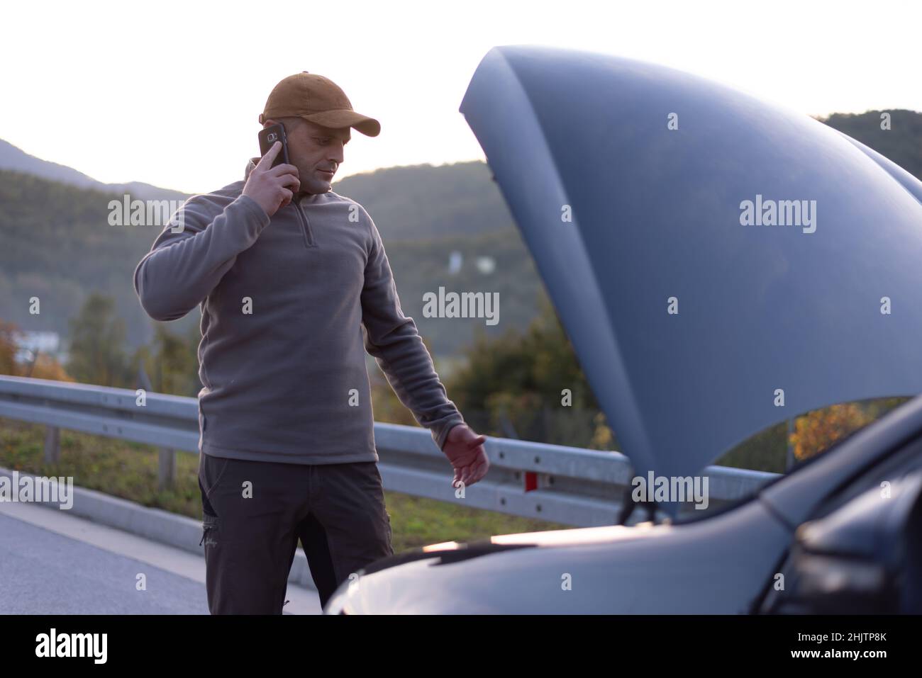 Man calling towing service for help on the road. Roadside assistance ...