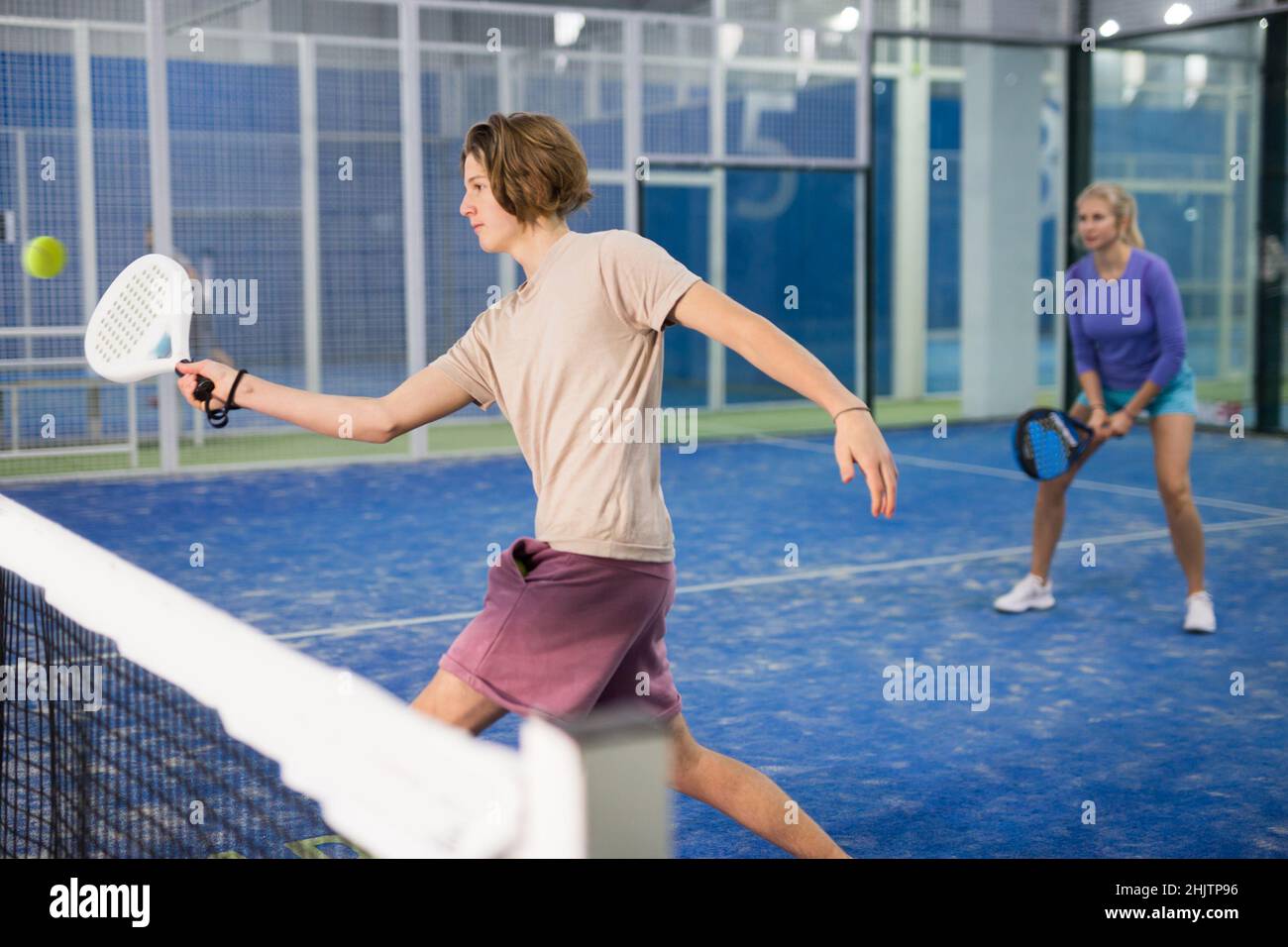Teenage boy and adult woman in padel court Stock Photo - Alamy
