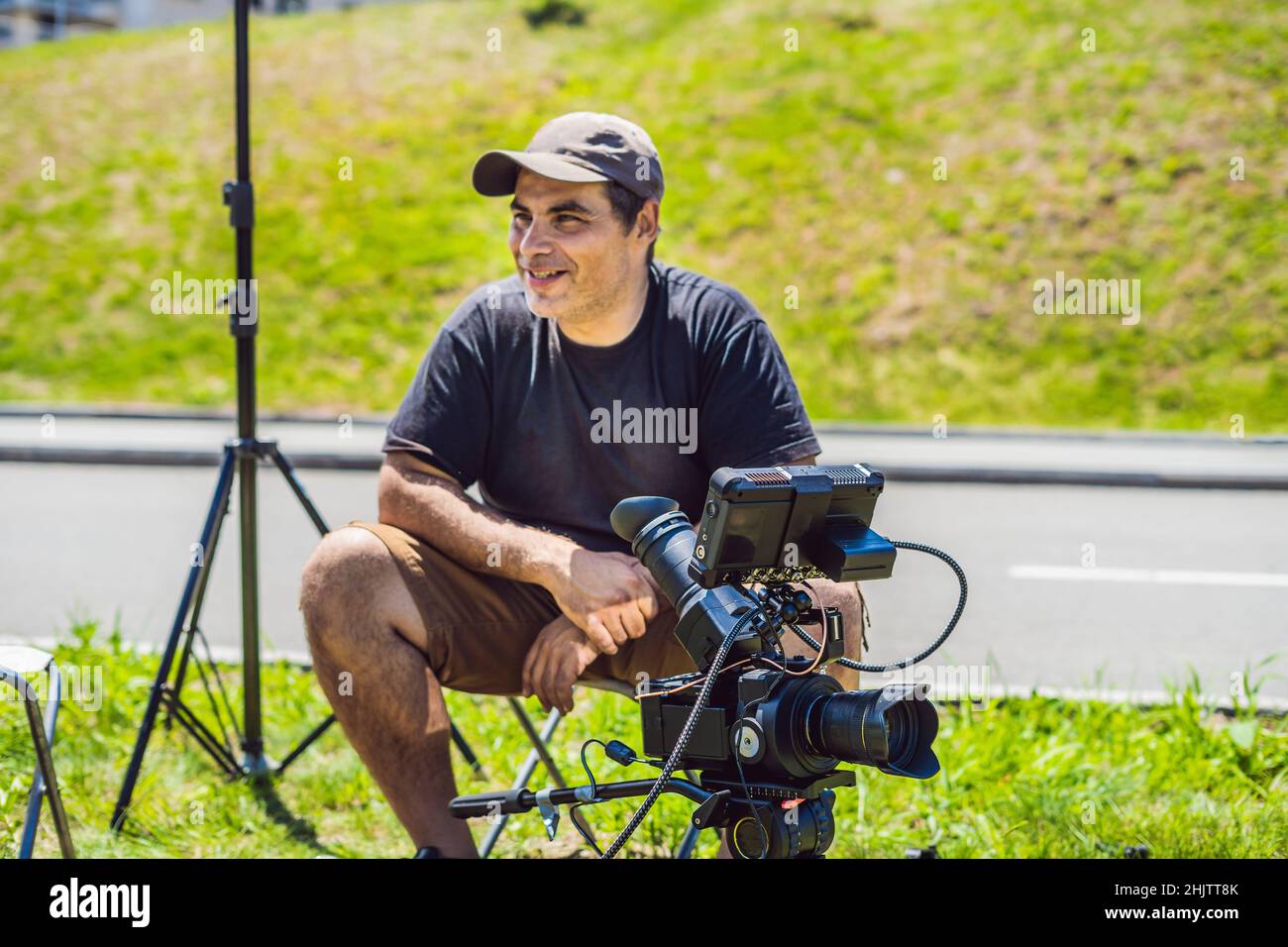 a professional cameraman prepares a camera and a tripod before shooting ...
