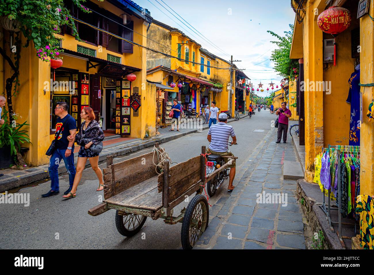 A old traditional cart pulled by a motorbike is in the middle of the ...