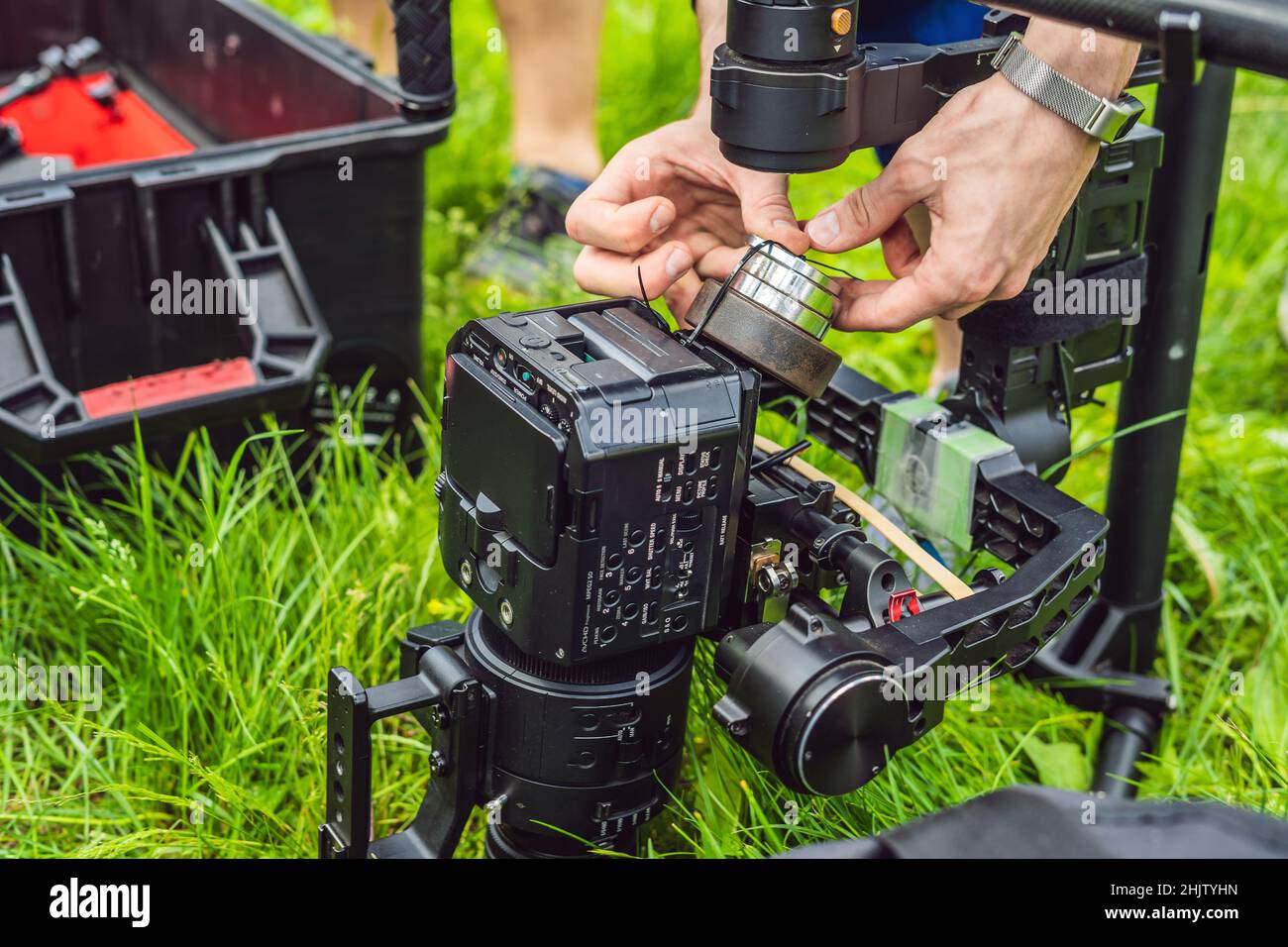 Cameraman setting up heavy duty professional 3-axis gimbal stabilizer ...