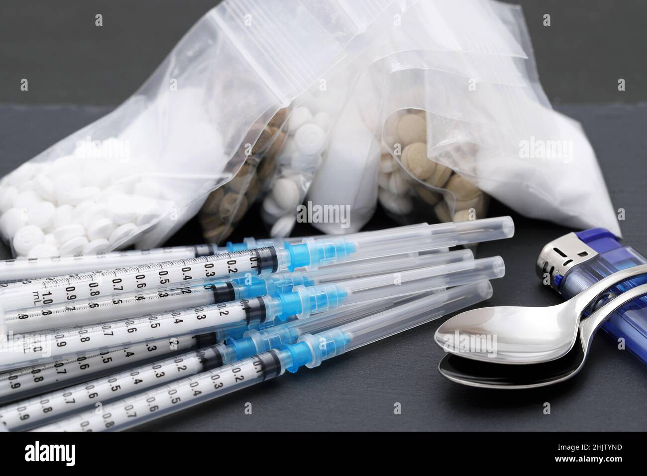 Drug injection syringe and cooked heroin in a bag on black background Stock Photo - Alamy