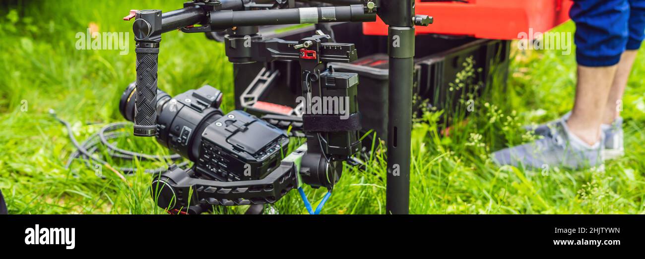 Cameraman setting up heavy duty professional 3-axis gimbal stabilizer ...