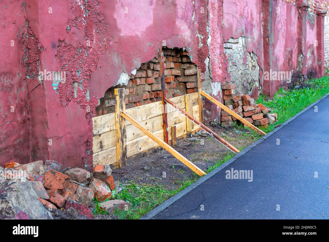 an old brick wall covered with plaster is falling apart and it is being ...