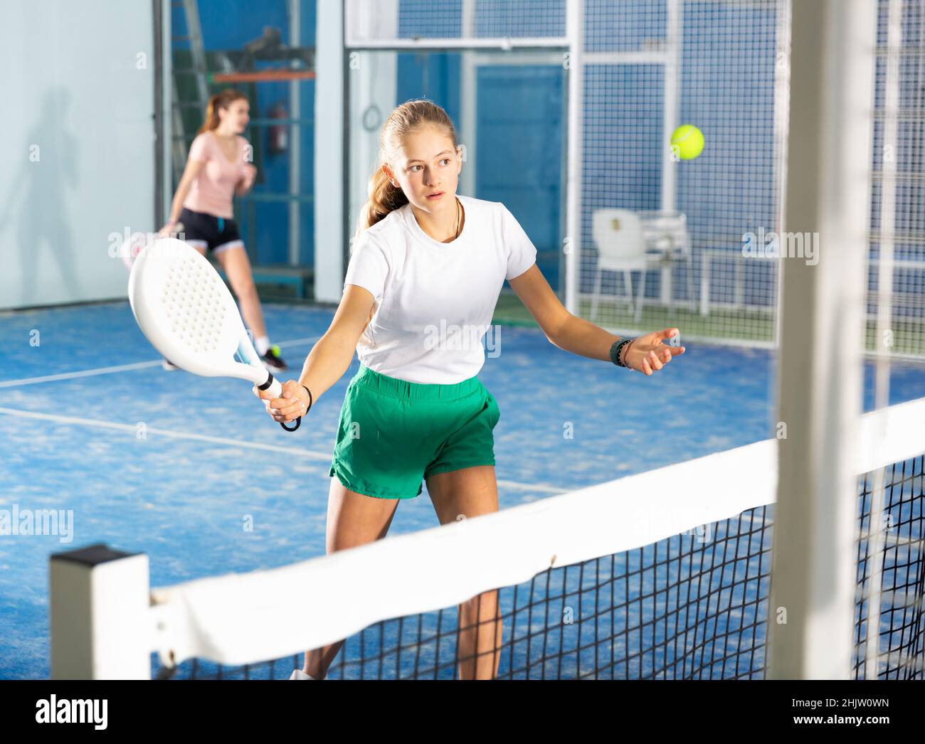 Teenage girl playing padel game on court Stock Photo - Alamy