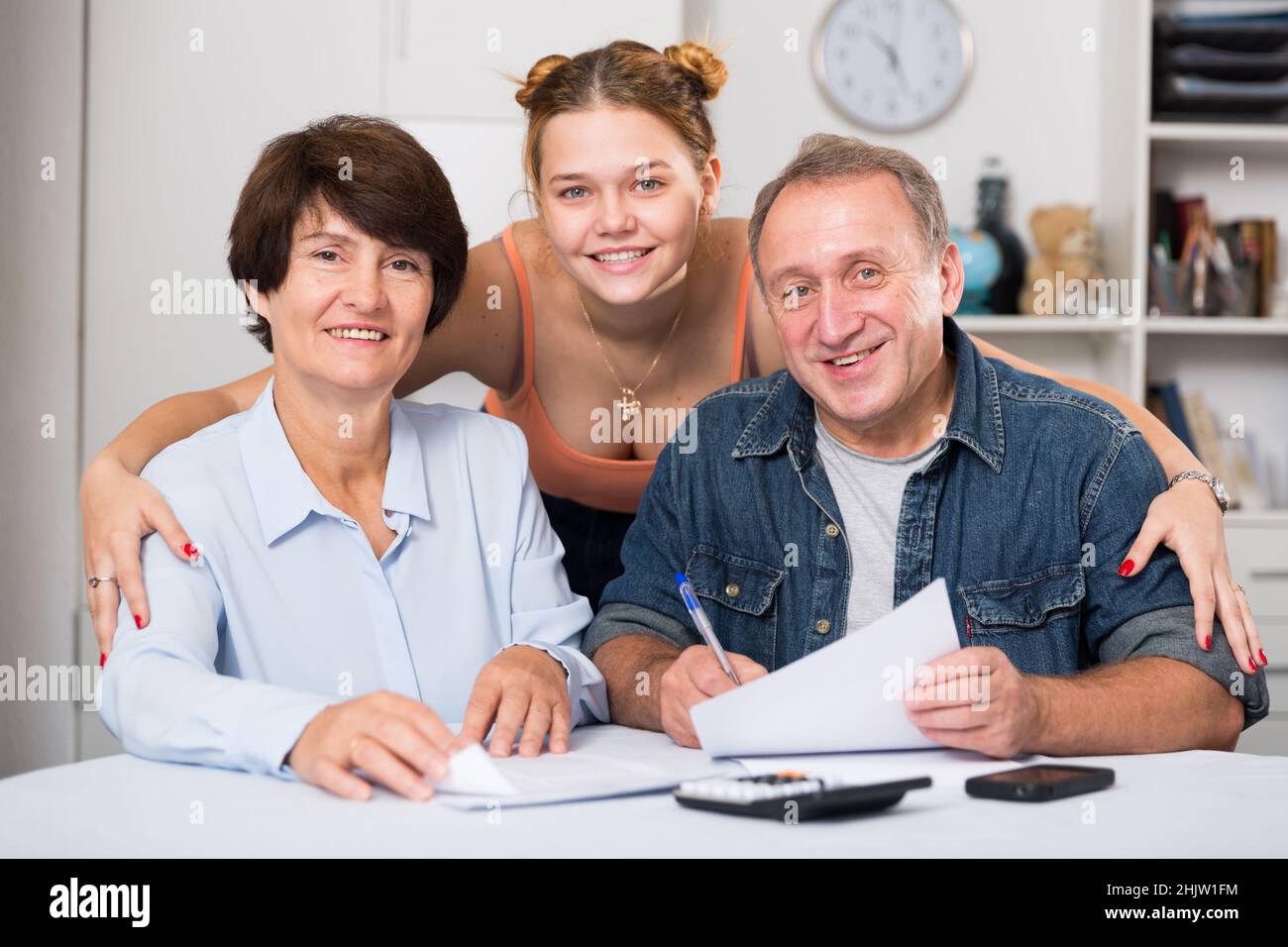 Adult couple is singing contract with their daughter Stock Photo - Alamy