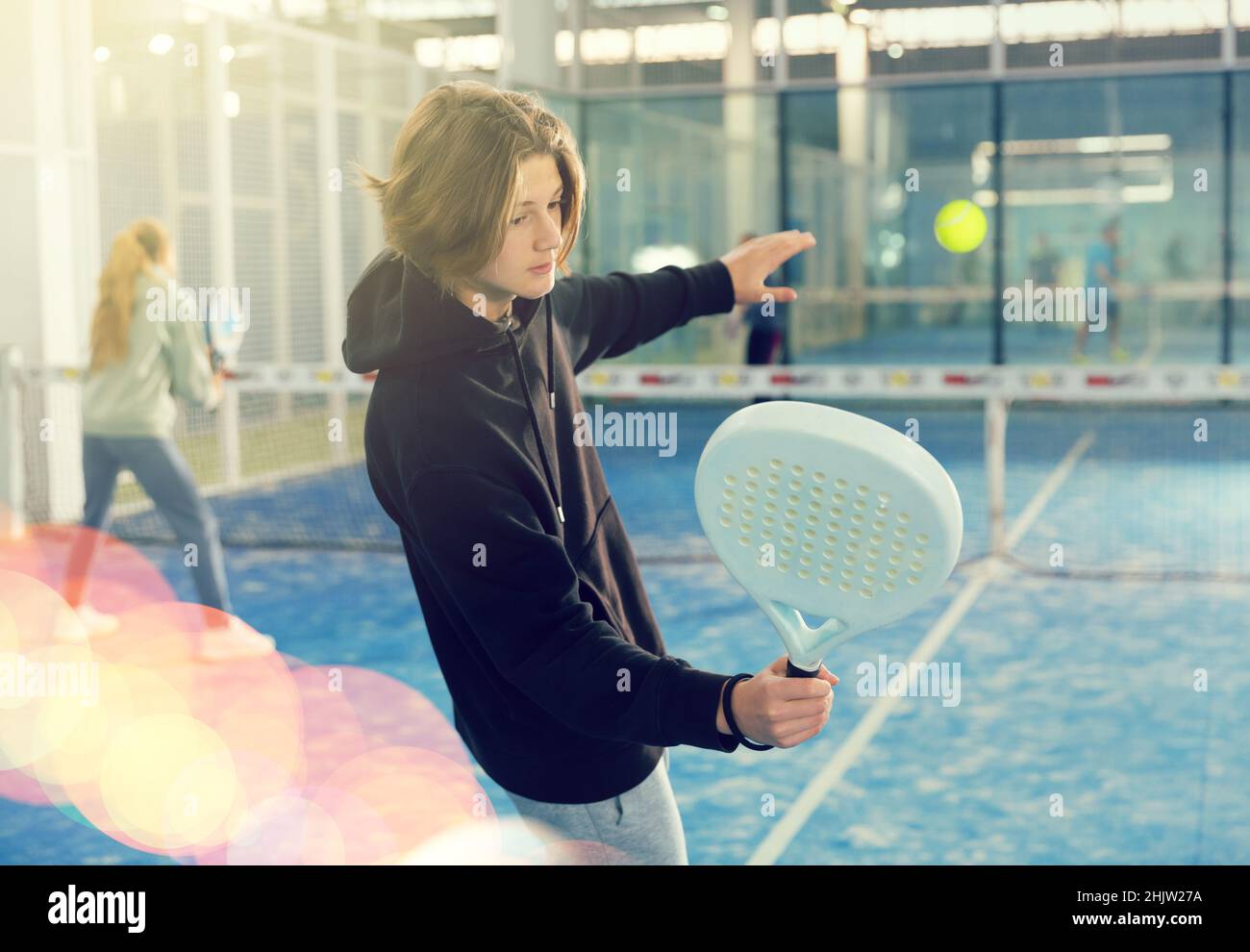 Teenage guy playing paddle tennis on padel court Stock Photo - Alamy
