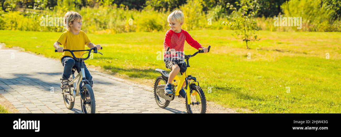 Two happy boys cycling in the park BANNER, LONG FORMAT Stock Photo - Alamy