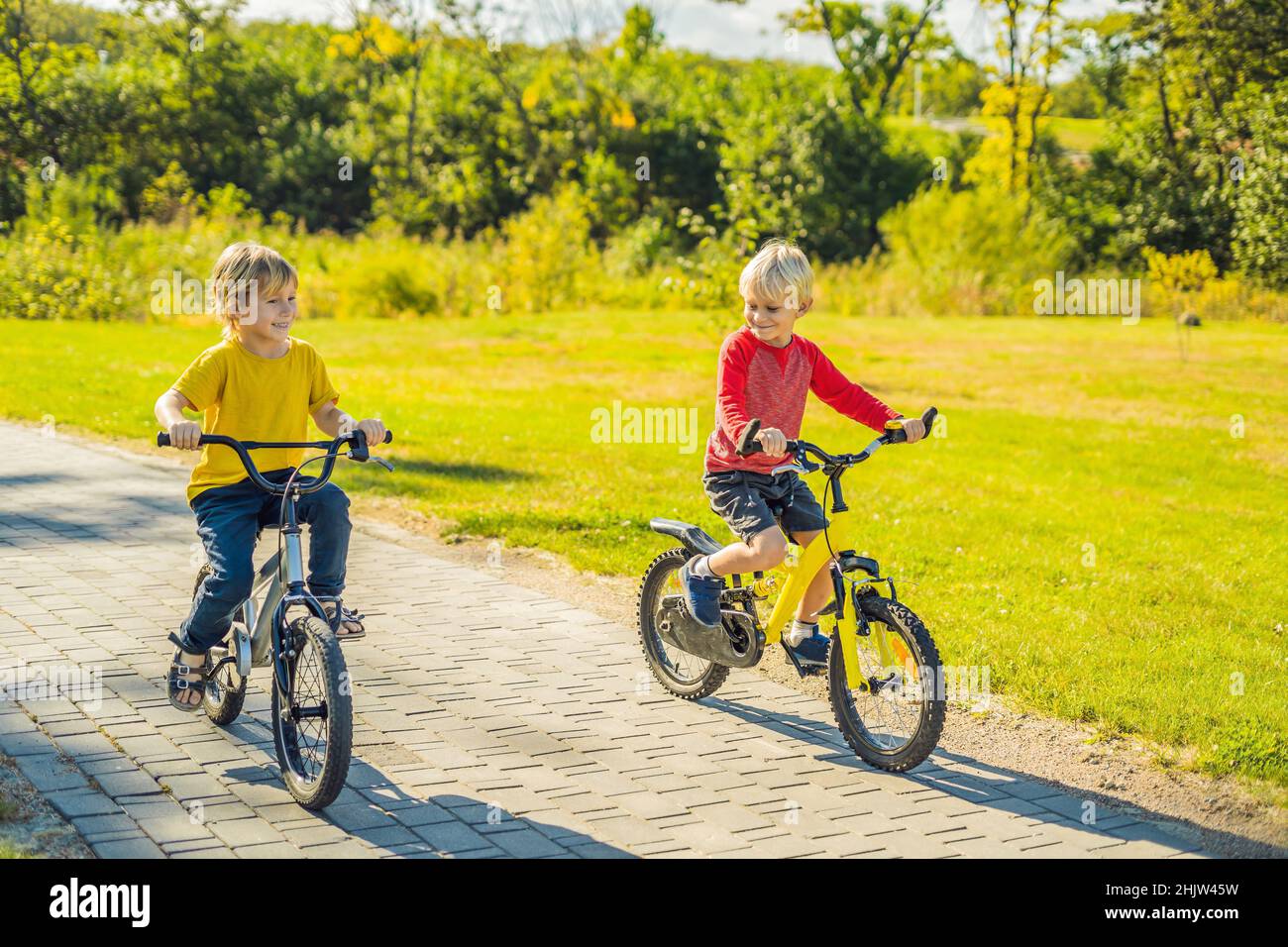 Two happy boys cycling in the park Stock Photo - Alamy