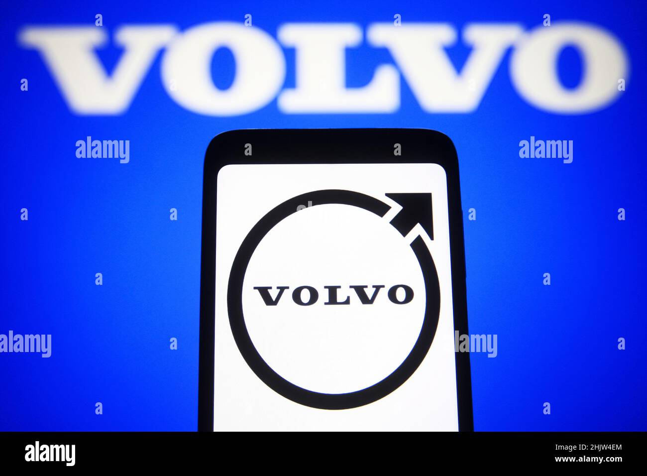 In this photo illustration, a Volvo logo is seen on a smartphone and a ...
