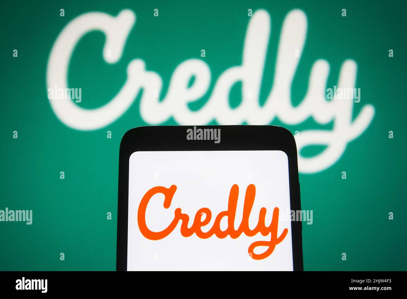 In this photo illustration, a Credly logo is seen on a smartphone and a computer screen. (Photo ...