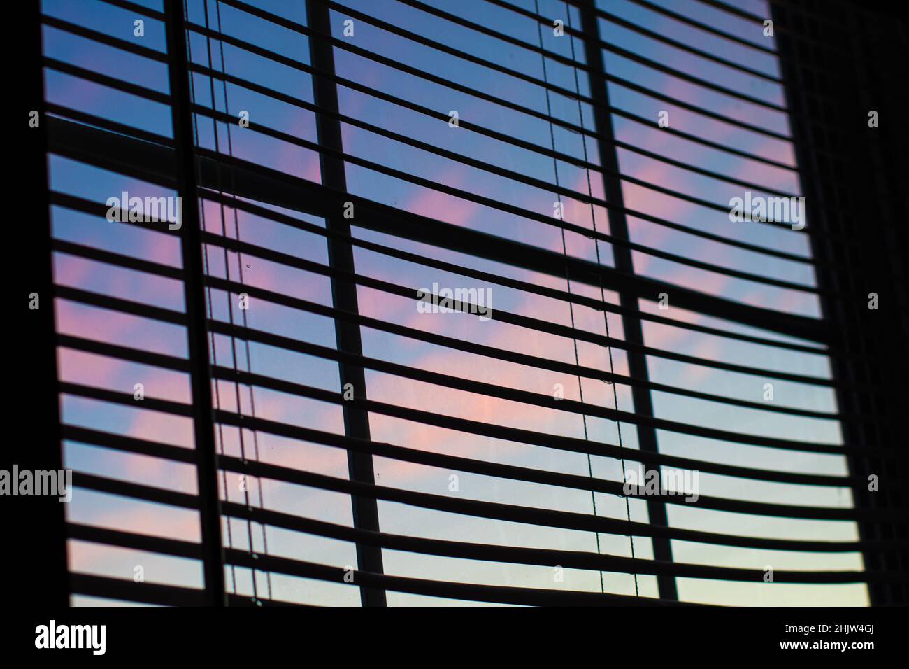 Beautiful pink blue sunset sky through a window with bilnds Stock Photo ...