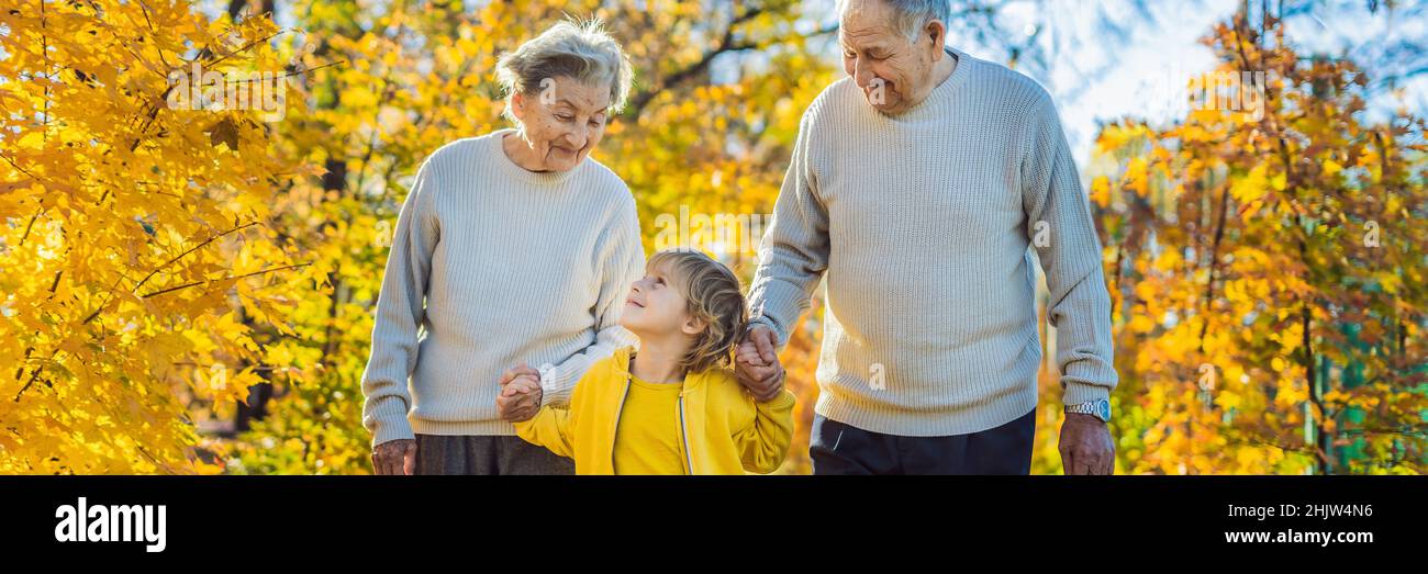 Senior couple with baby grandson in the autumn park. Great-grandmother ...