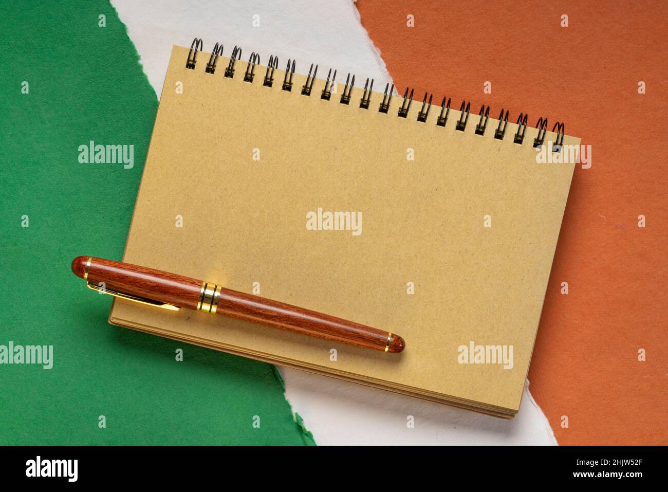 blank notebook against paper abstract in colors of national flag of ...