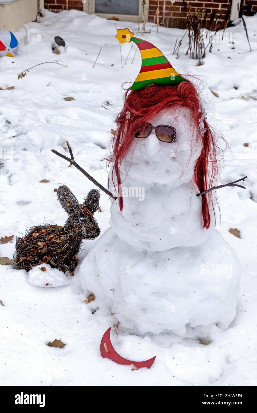 Hip snowman wearing a red wig, sunglasses and an elf's party hat beside ...