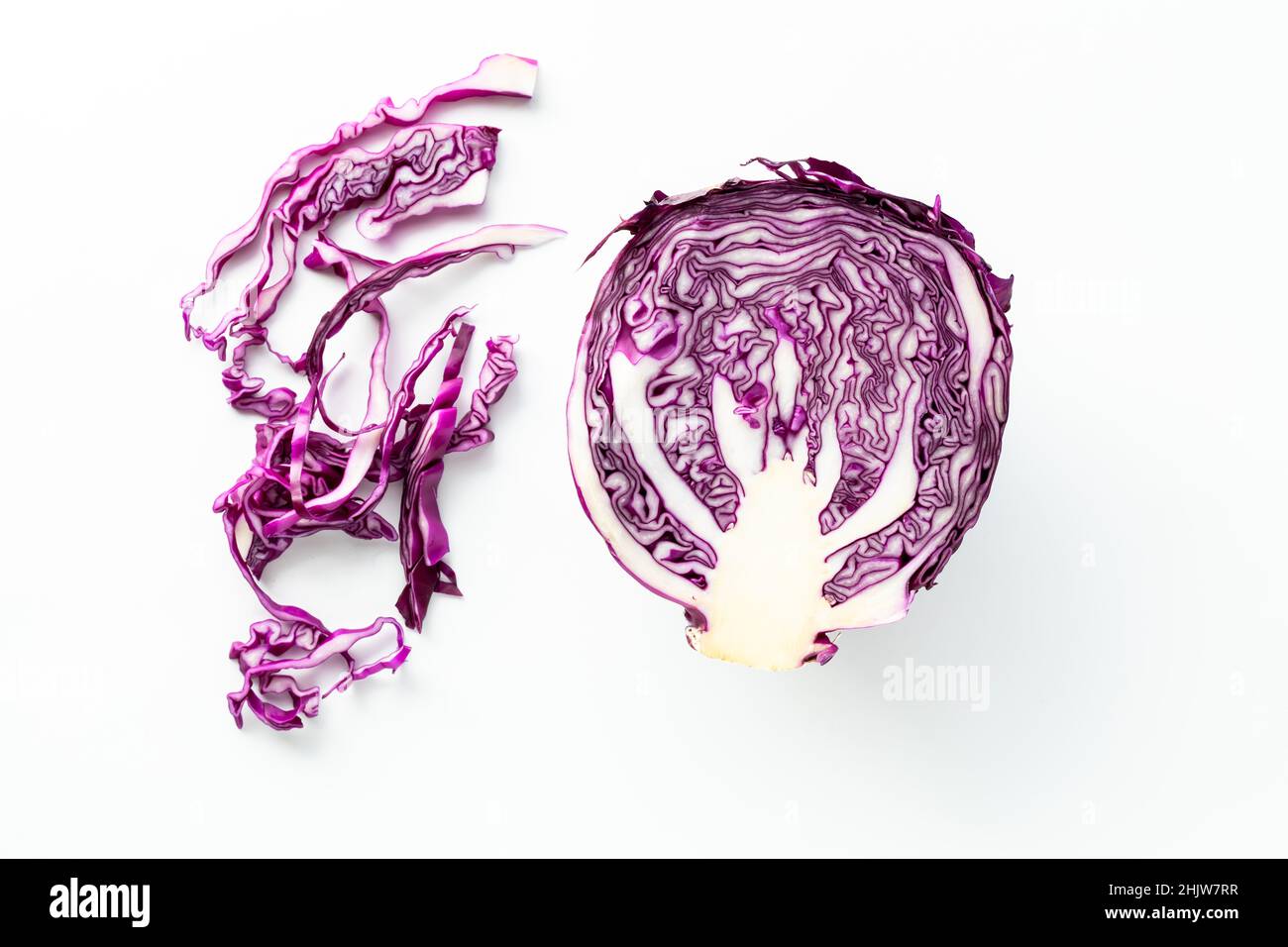 Cross section view of a purple cabbage with shavings of cabbage to the ...