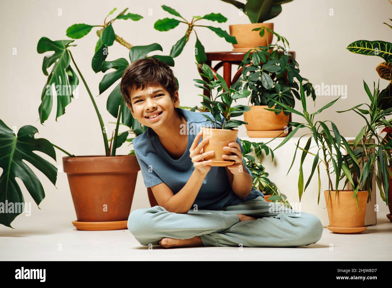 Flexible indian boy sitting in easy pose in the middle of a room full ...