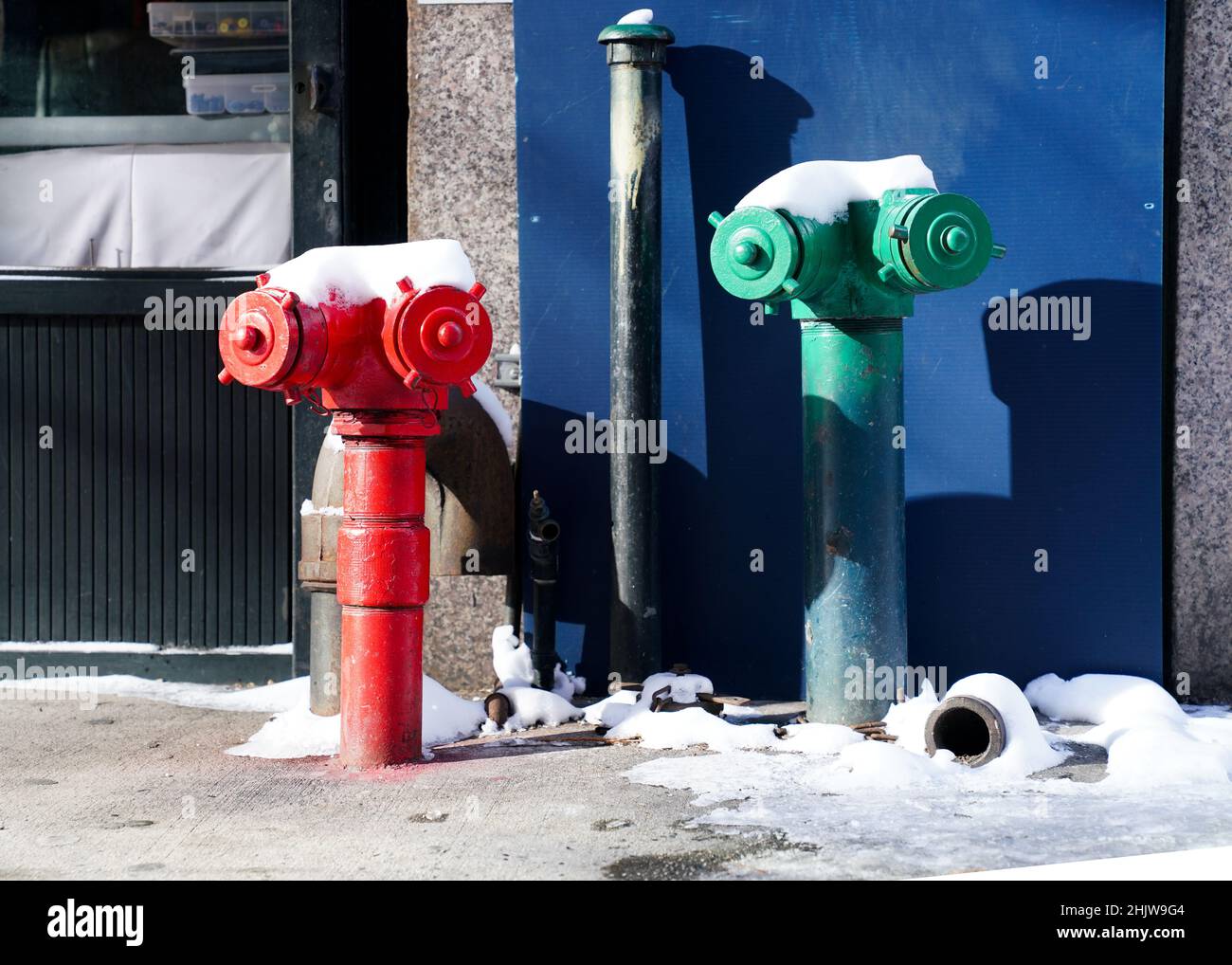 Joy and color: two fire hydrants, red and green, capped with snow seen ...