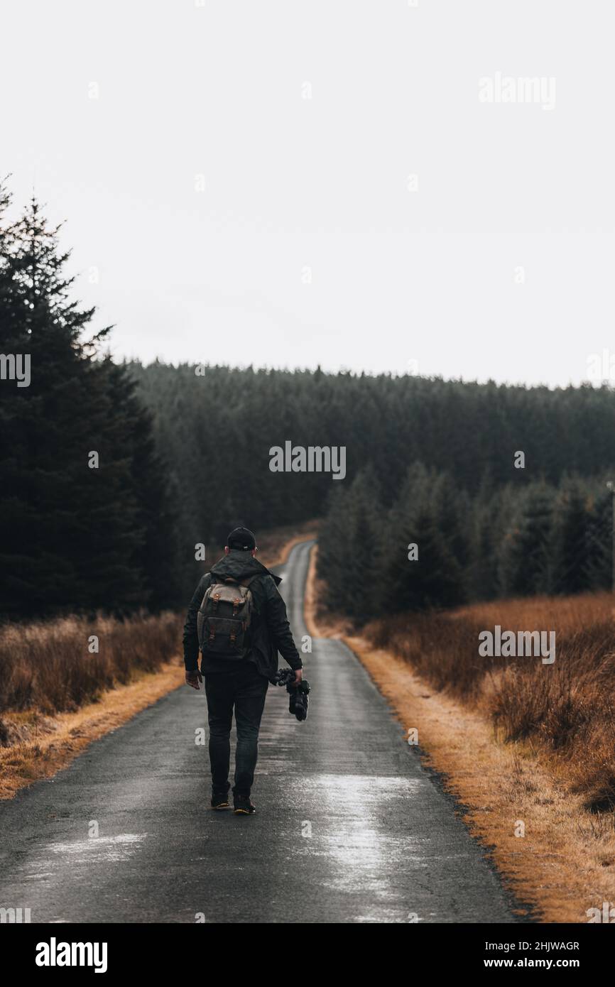Beautiful view of a man on a road by the forest Stock Photo - Alamy