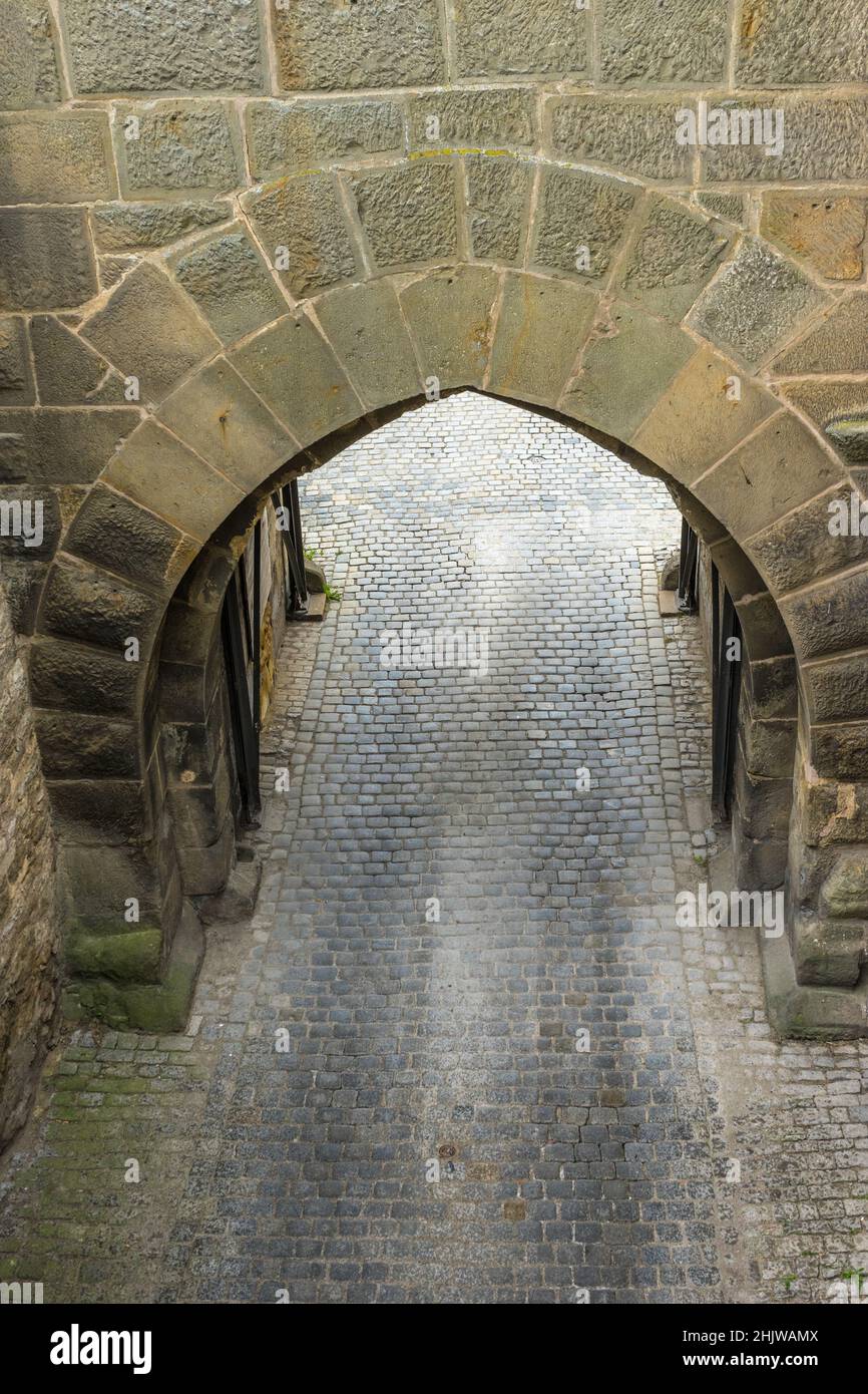 Vertical shot of a stone arch above the brick pavement in Rothenburg ob ...