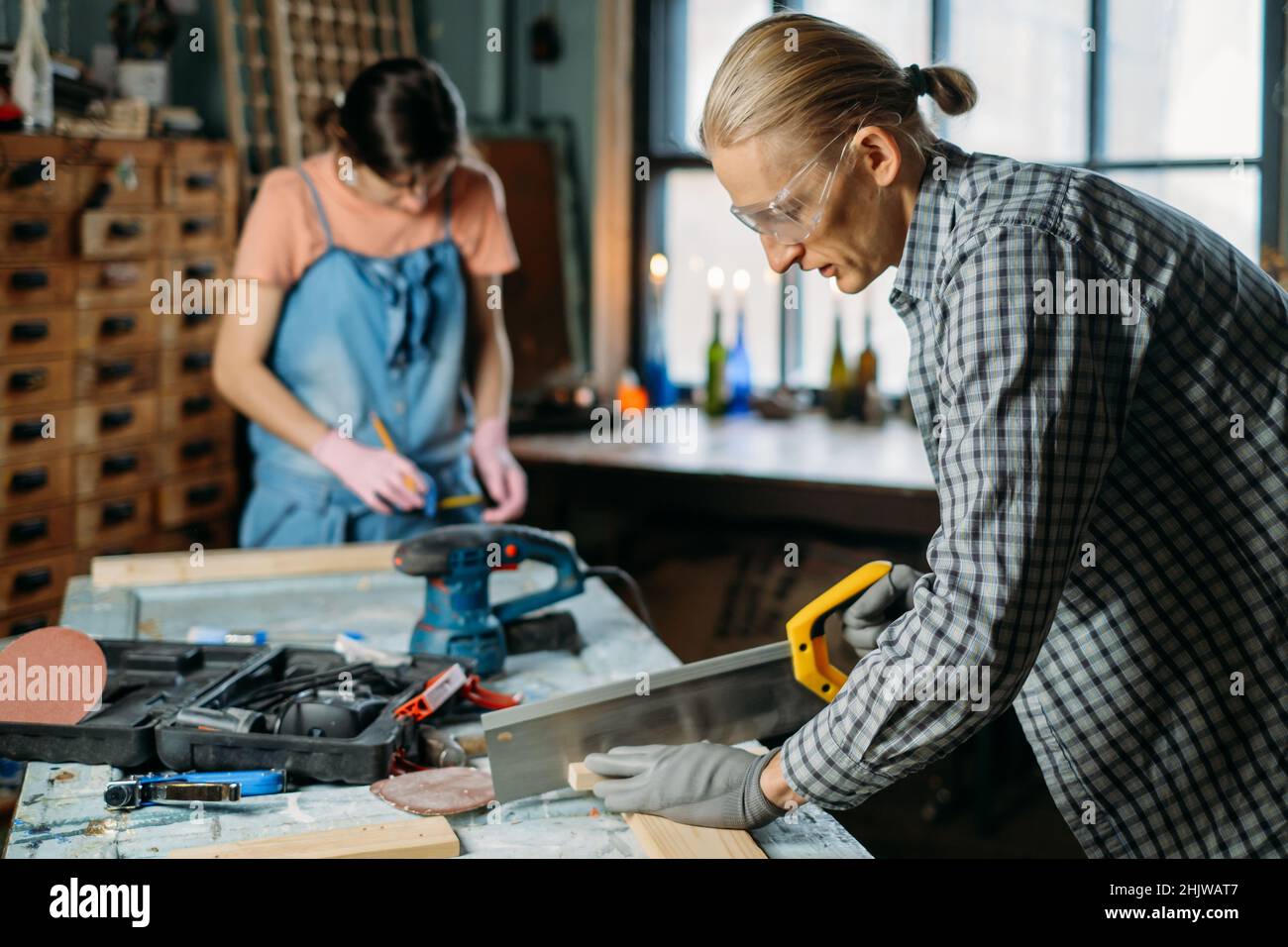 Man and woman working in workshop, doing furniture, reuse old materials ...
