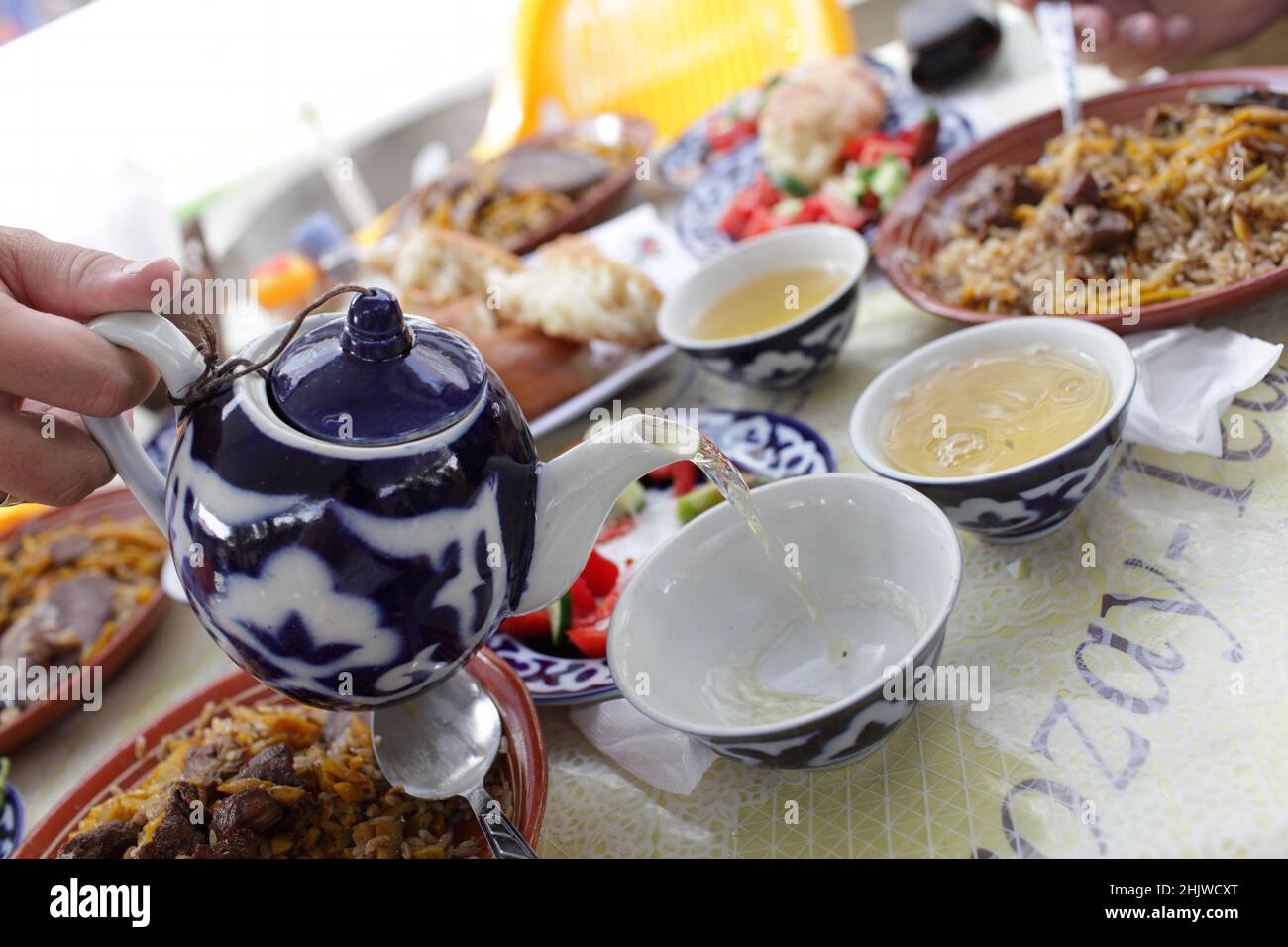 Pouring of green tea into cup in the uzbek restaurant, Tashkent Stock ...