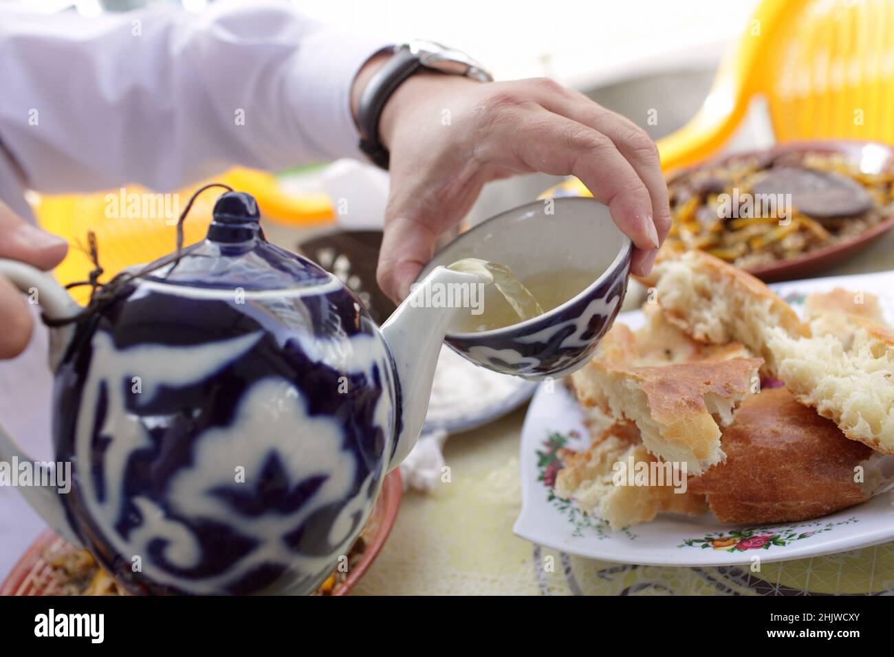 Man pouring tea into cup from teapot, Uzbekistan, Tashkent Stock Photo ...