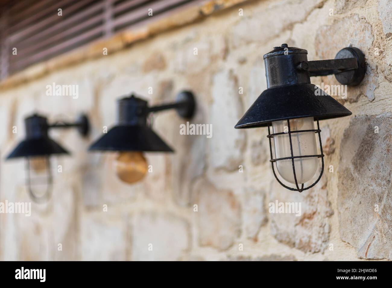 Beautiful street lamps on a stone wall. Background texture of the stone ...