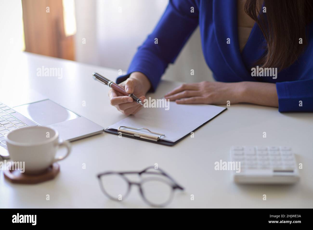 Cropped image, Businesswoman in blue suit signing a documents at her ...
