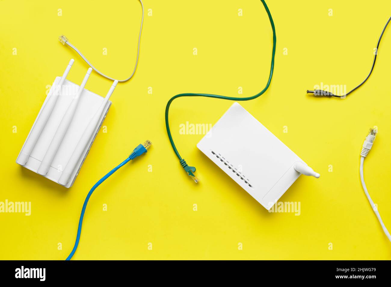 Wi-Fi router with antennas and network cables on color background Stock ...