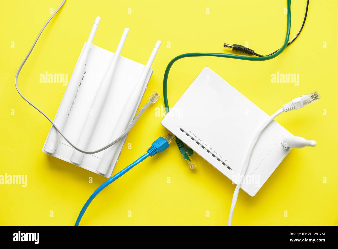 Wi-Fi router with antennas and network cables on color background Stock ...