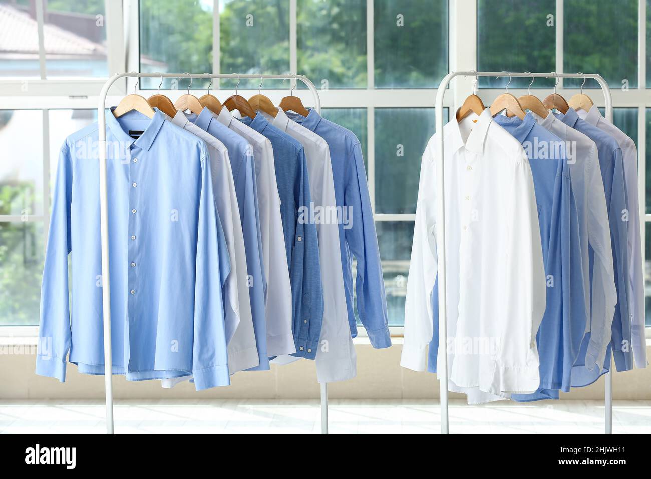 Racks with clean shirts after dry-cleaning Stock Photo - Alamy