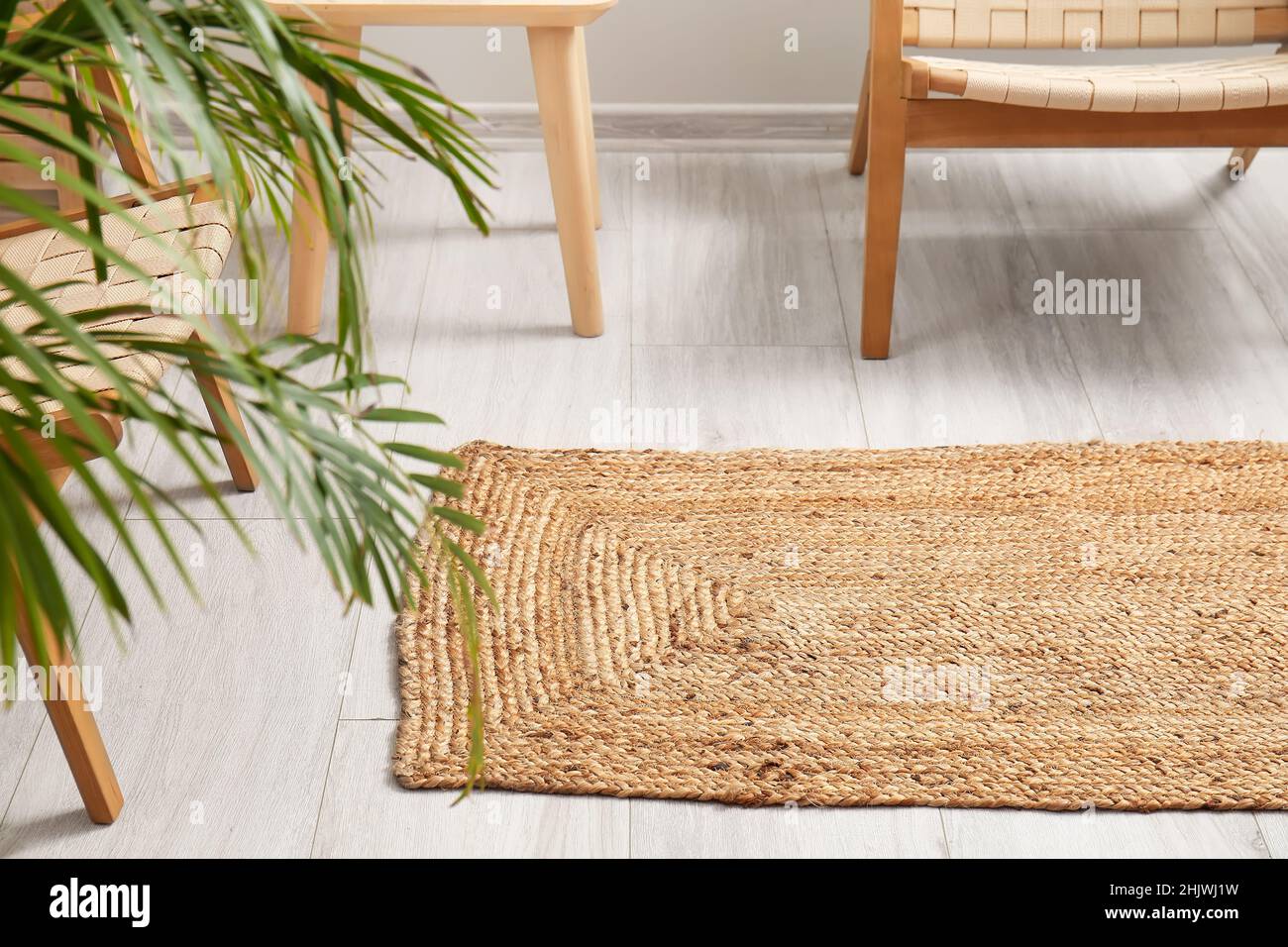 Wicker rug on light wooden floor in room interior Stock Photo - Alamy