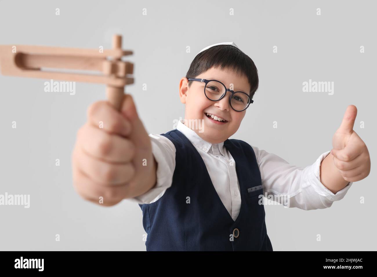 Little Jewish boy with gragger for Purim holiday showing thumb-up ...