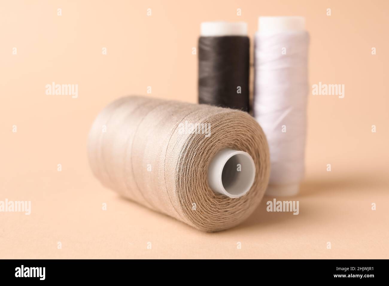 Different sewing thread spools on light background Stock Photo - Alamy