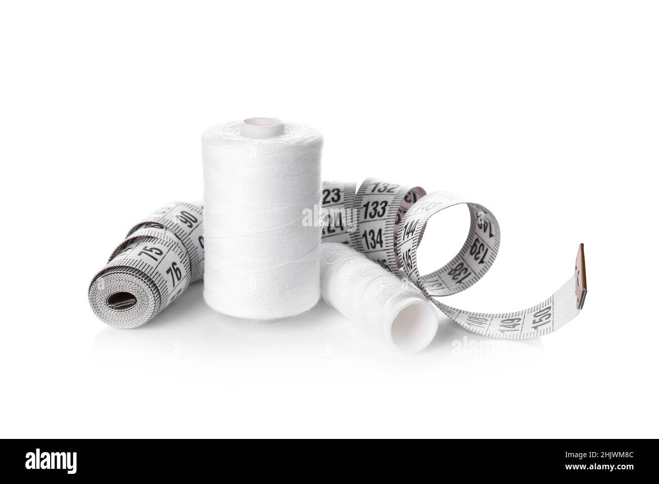 White thread spools and measuring tape on white background Stock Photo ...
