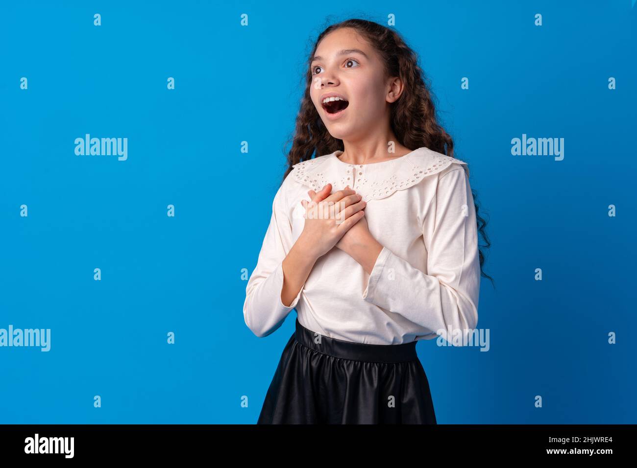 Shocked and surprised young teen girl against blue background Stock ...