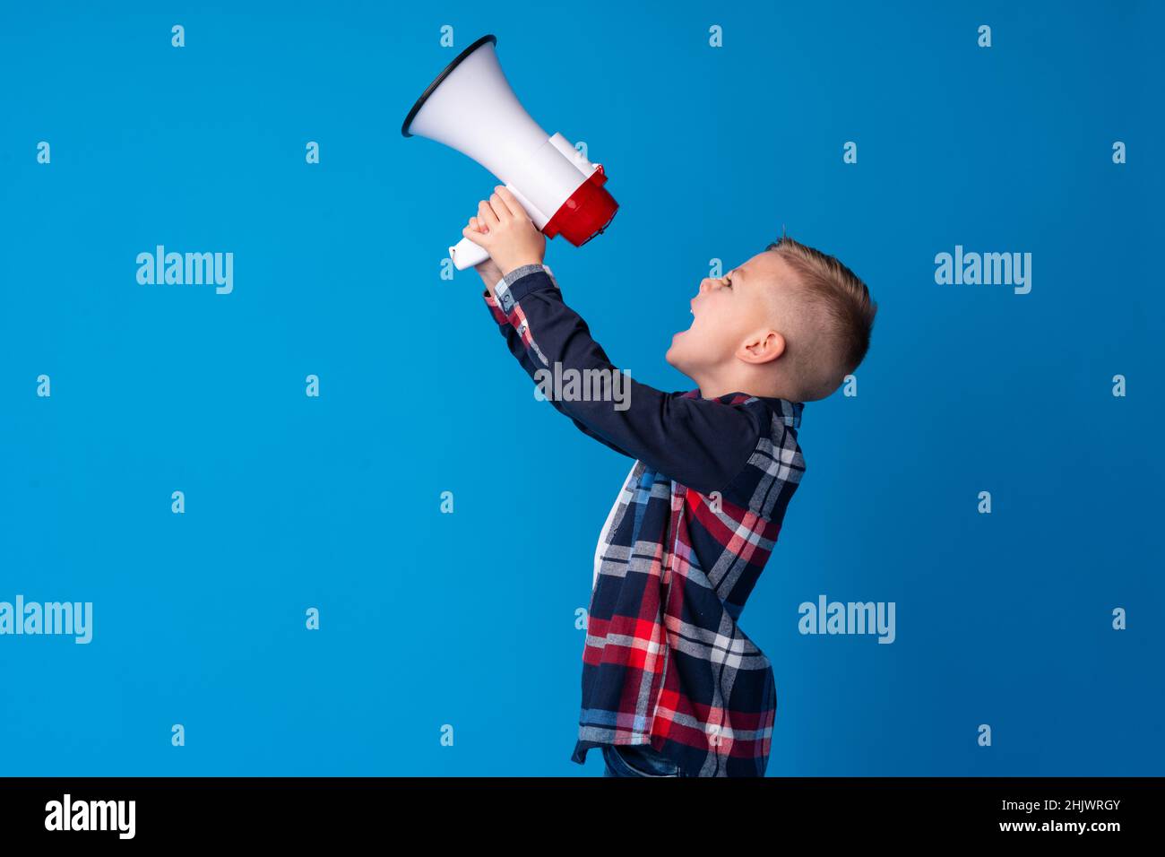Cute little boy with megaphone on blue background Stock Photo - Alamy