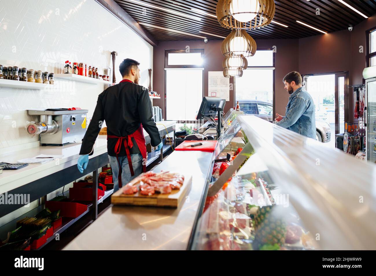 Butcher in a grocery store at work Stock Photo - Alamy
