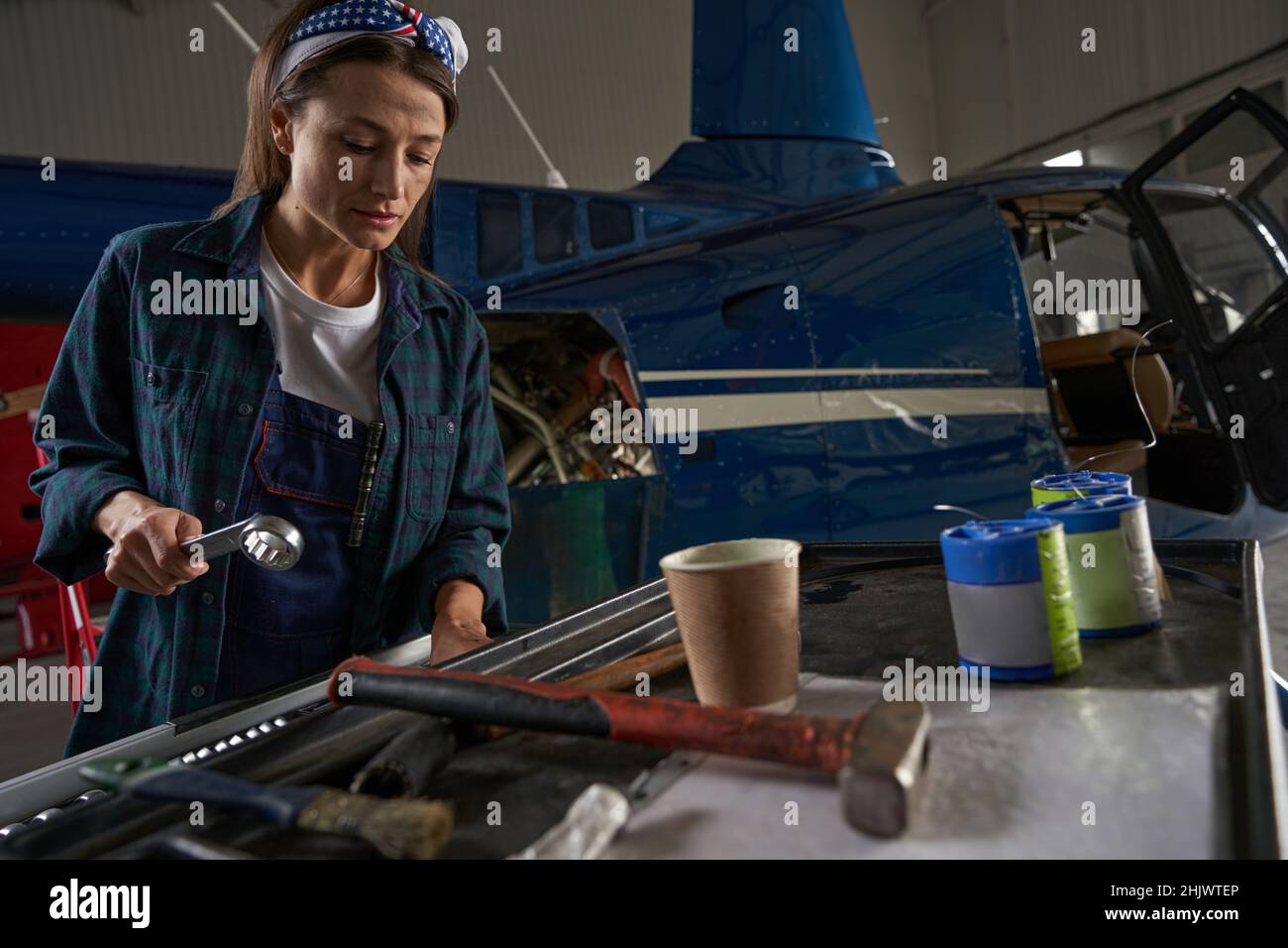 Woman air frame engineer standing in front of the private jet airplane ...
