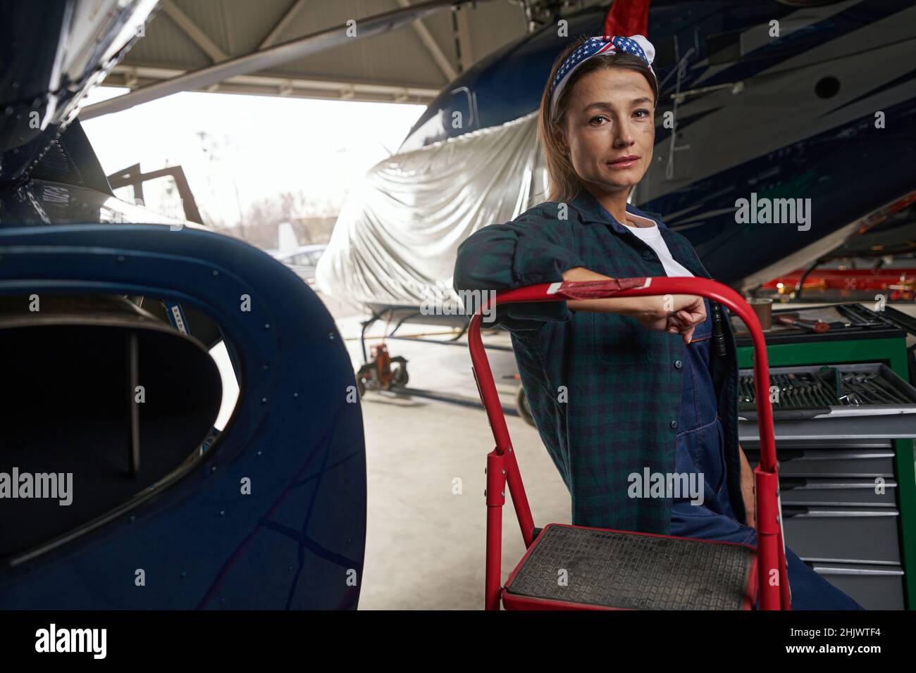 Beautiful elegant female relief engineer working in aviation hangar ...