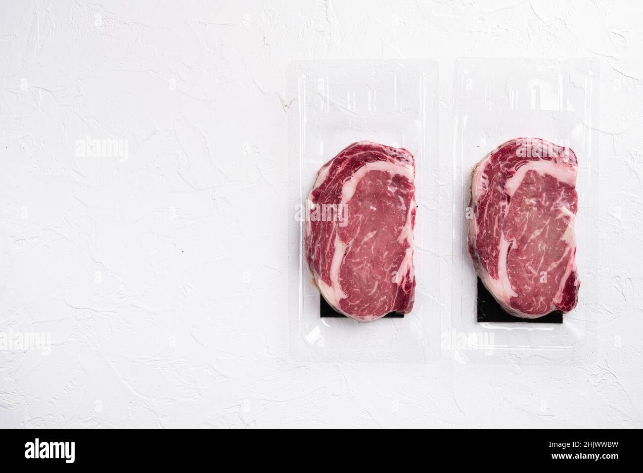 Marbled beef from the store set, on white stone table background, top ...