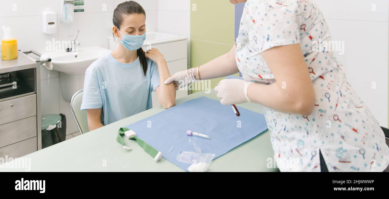 Taking a blood test from a vein in the treatment room. Nurse pricking a ...