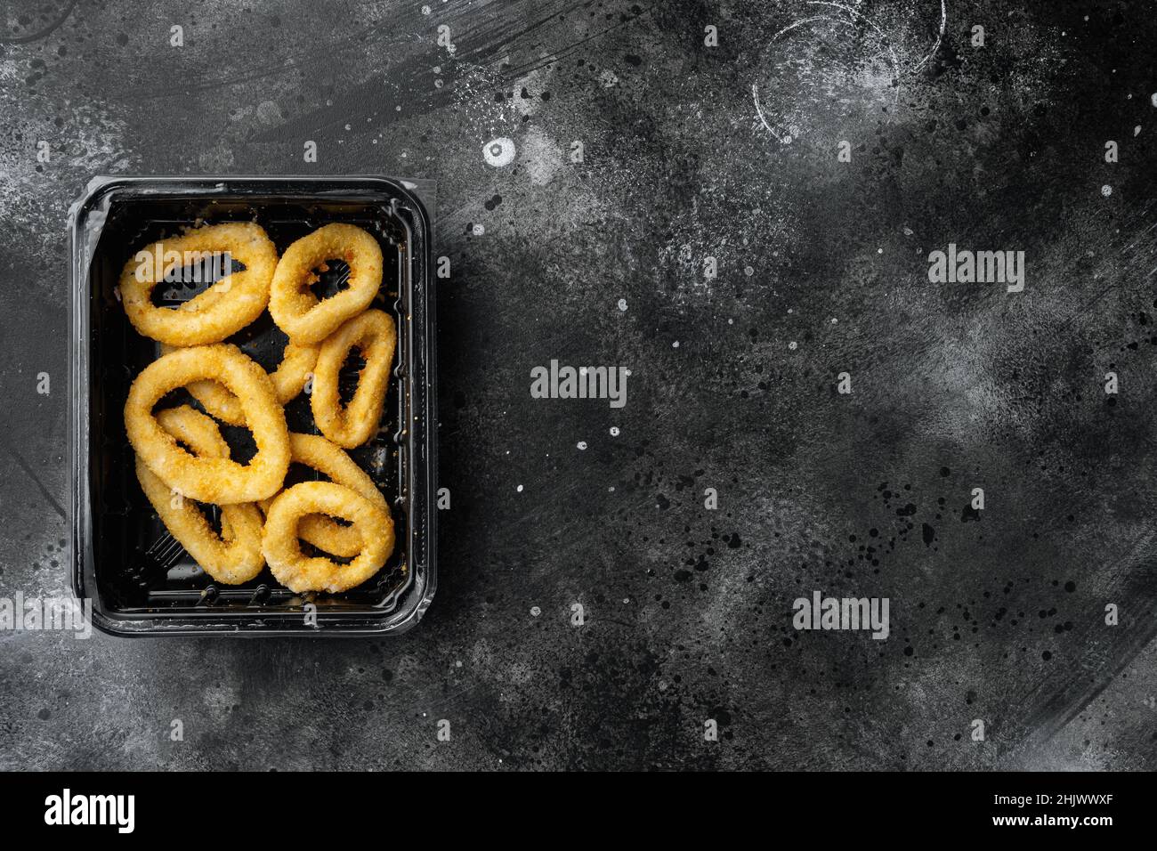 Raw Crispy deep fried onion or Calamari ring plastic pack set, on black ...
