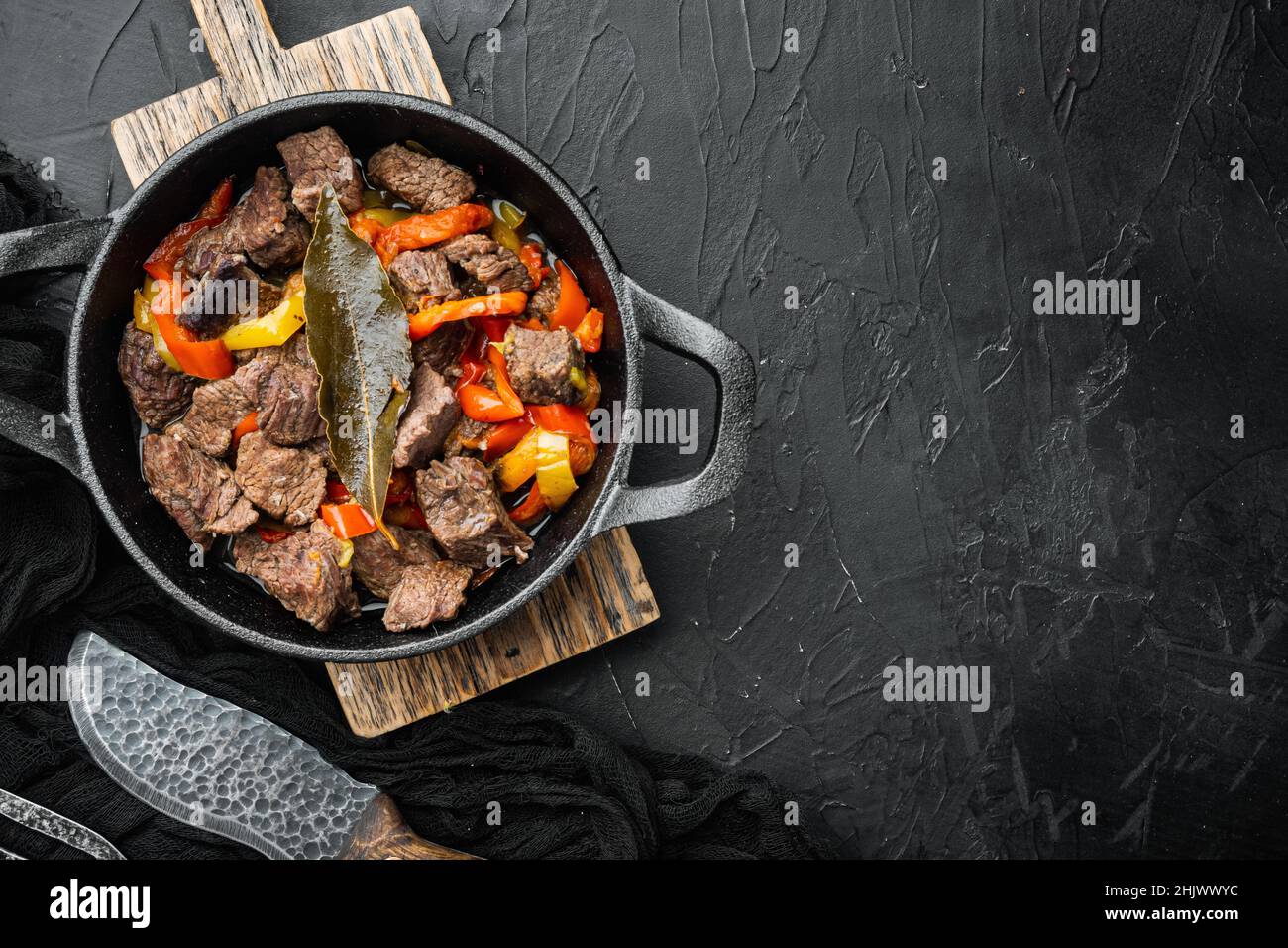 Goulash, beef stew set, in cast iron frying pan, on black stone ...