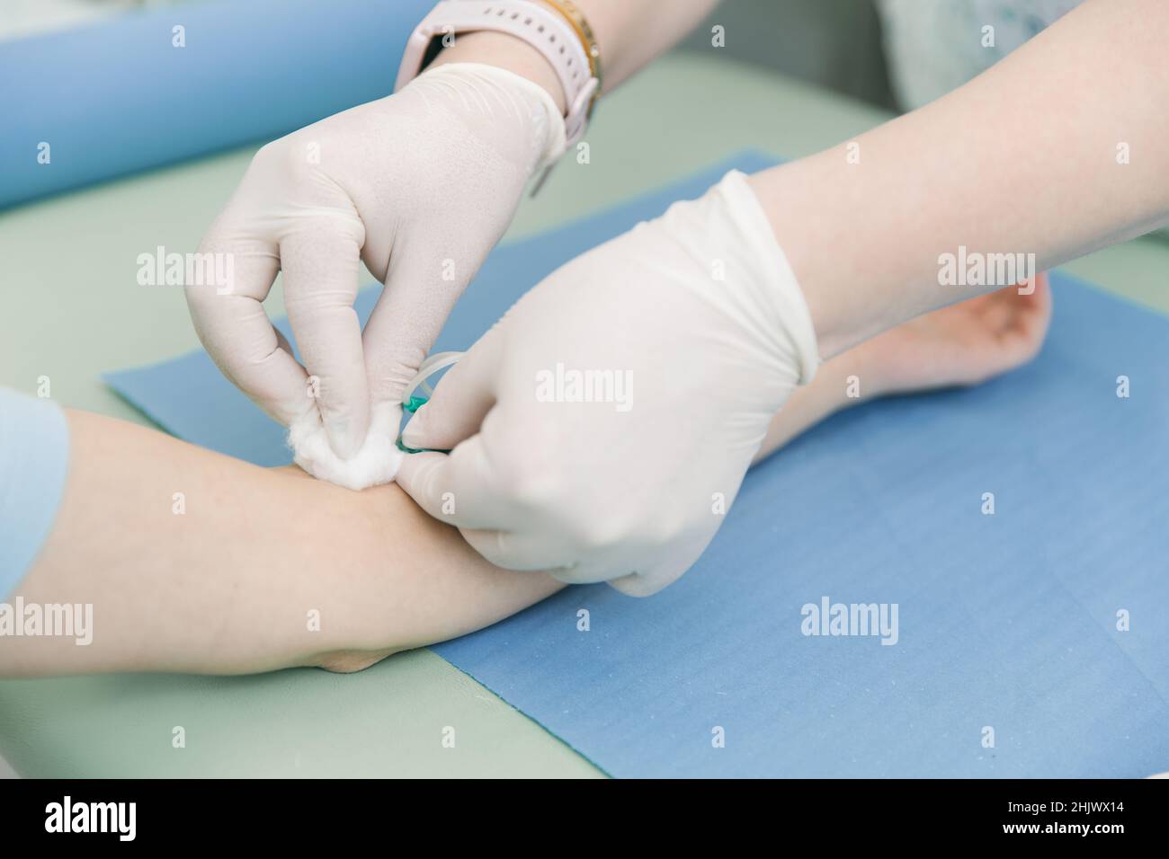 Taking a blood test from a vein in the treatment room. Nurse pricking a ...